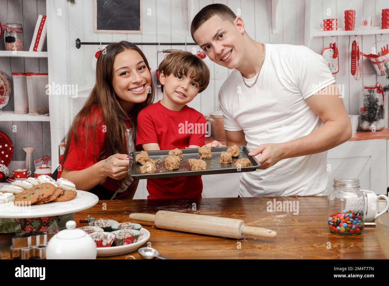 A family of two brothers and sister preparing cookies for Christmas ...