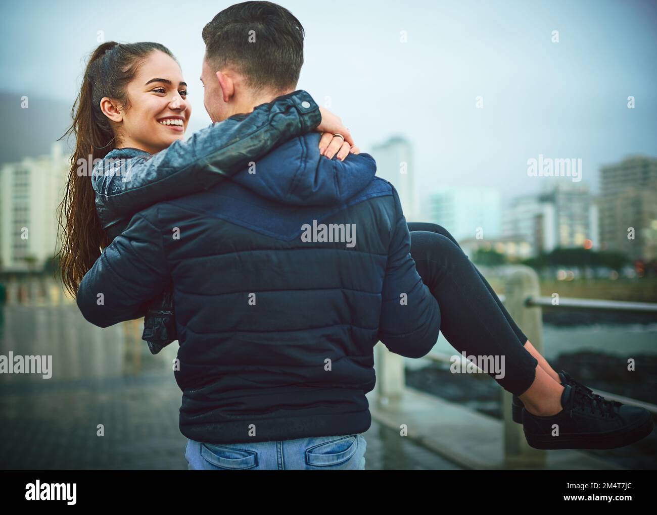 My hero. a young man romantically carrying his girlfriend outdoors ...