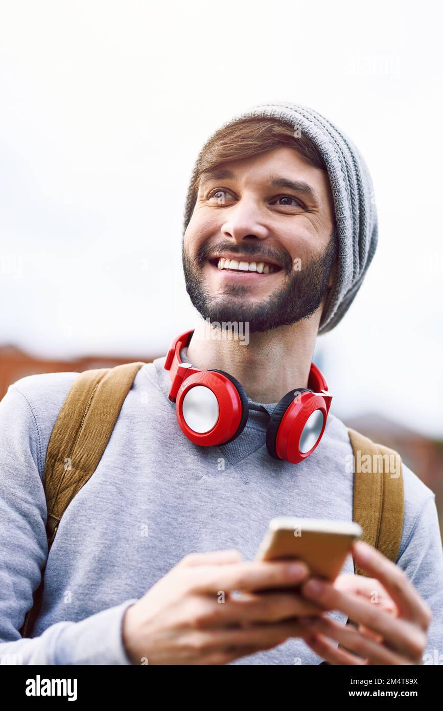 Making moves around town. a young man using his mobile phone while out ...