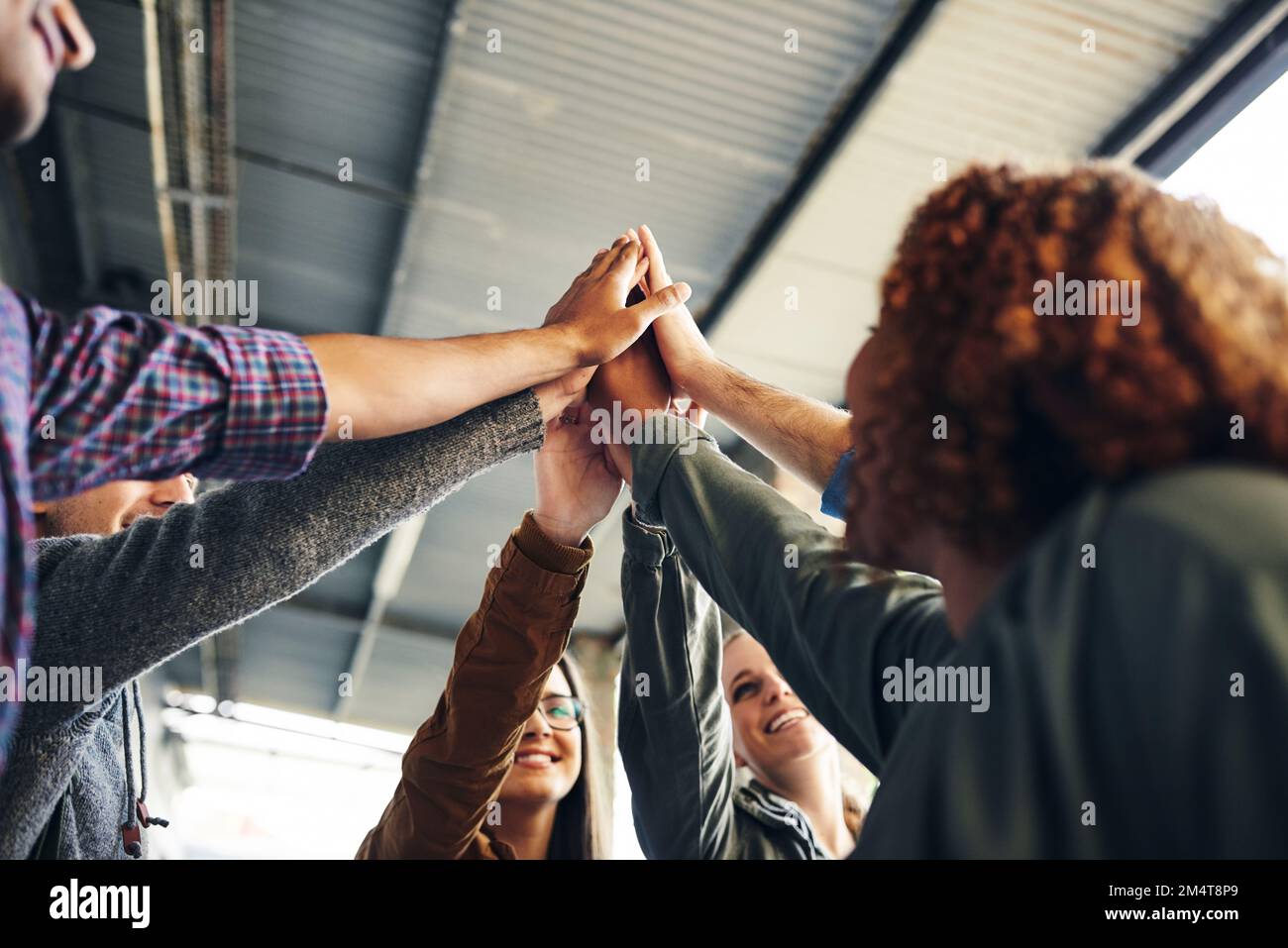 College. Bring it on. a group of young students joining their hands ...