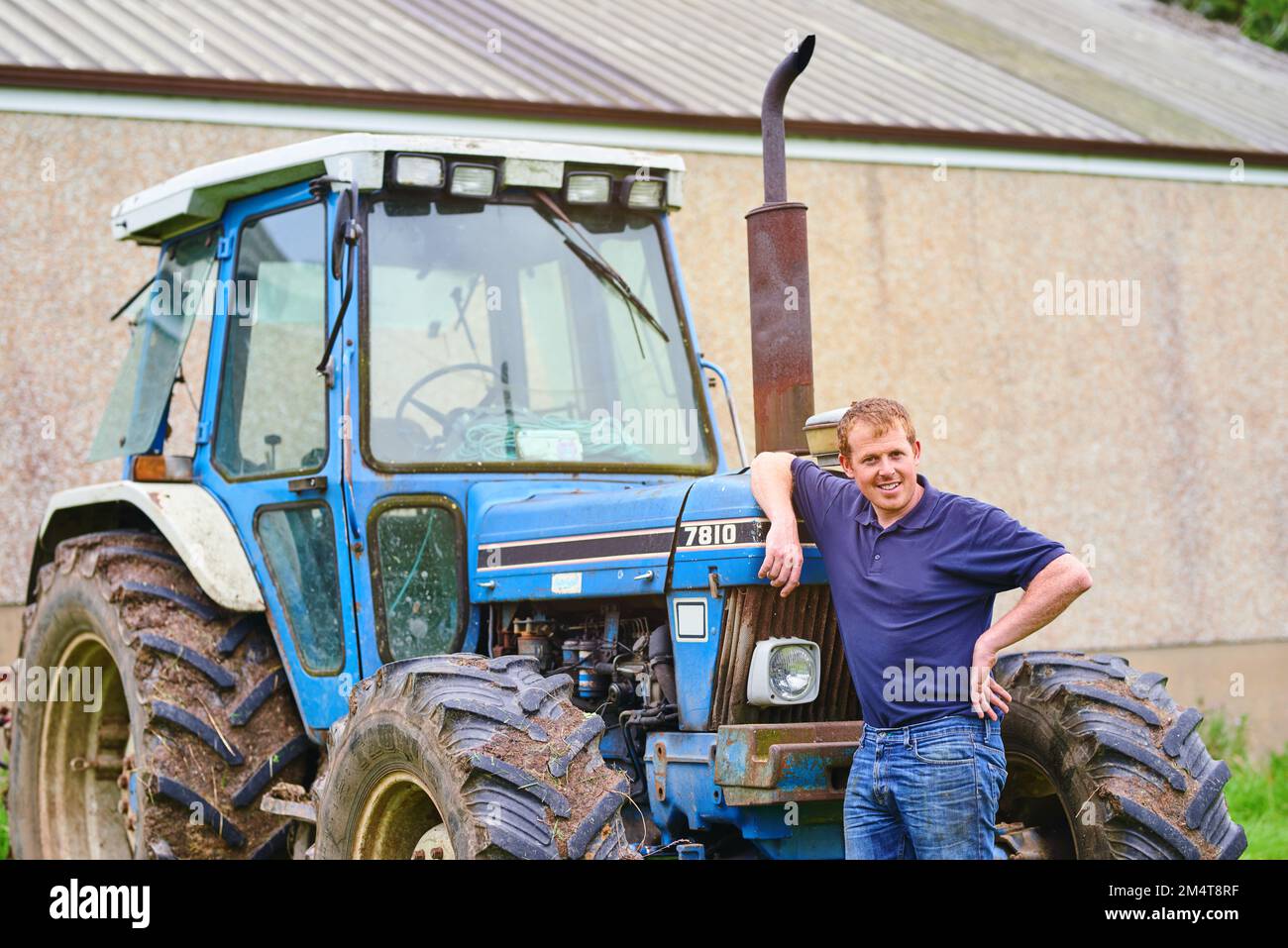 My tractor means business and so do I. a farmer standing next to a ...