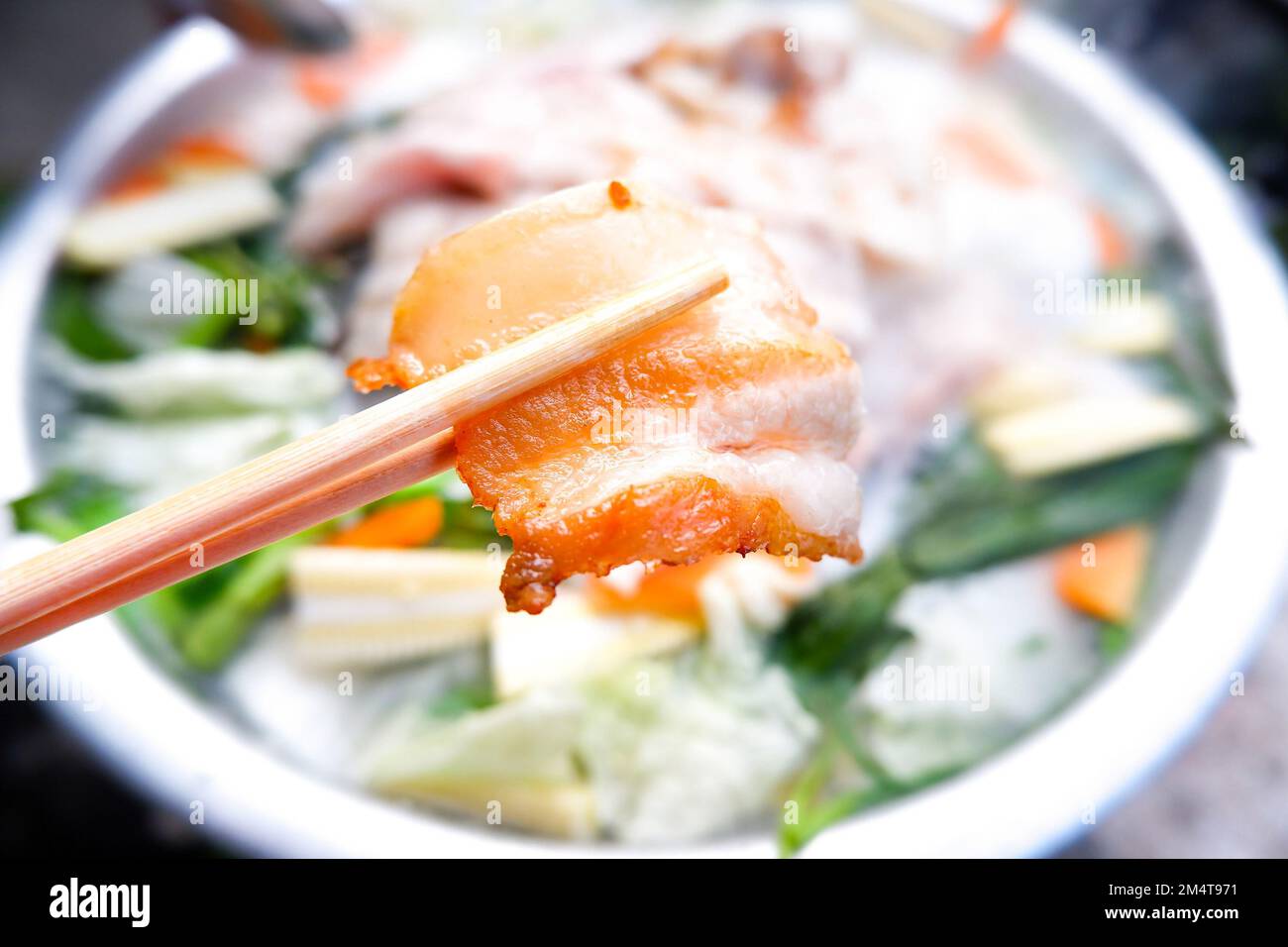 Close up of sliced pork belly grilled with bamboo chopsticks and a Thai ...