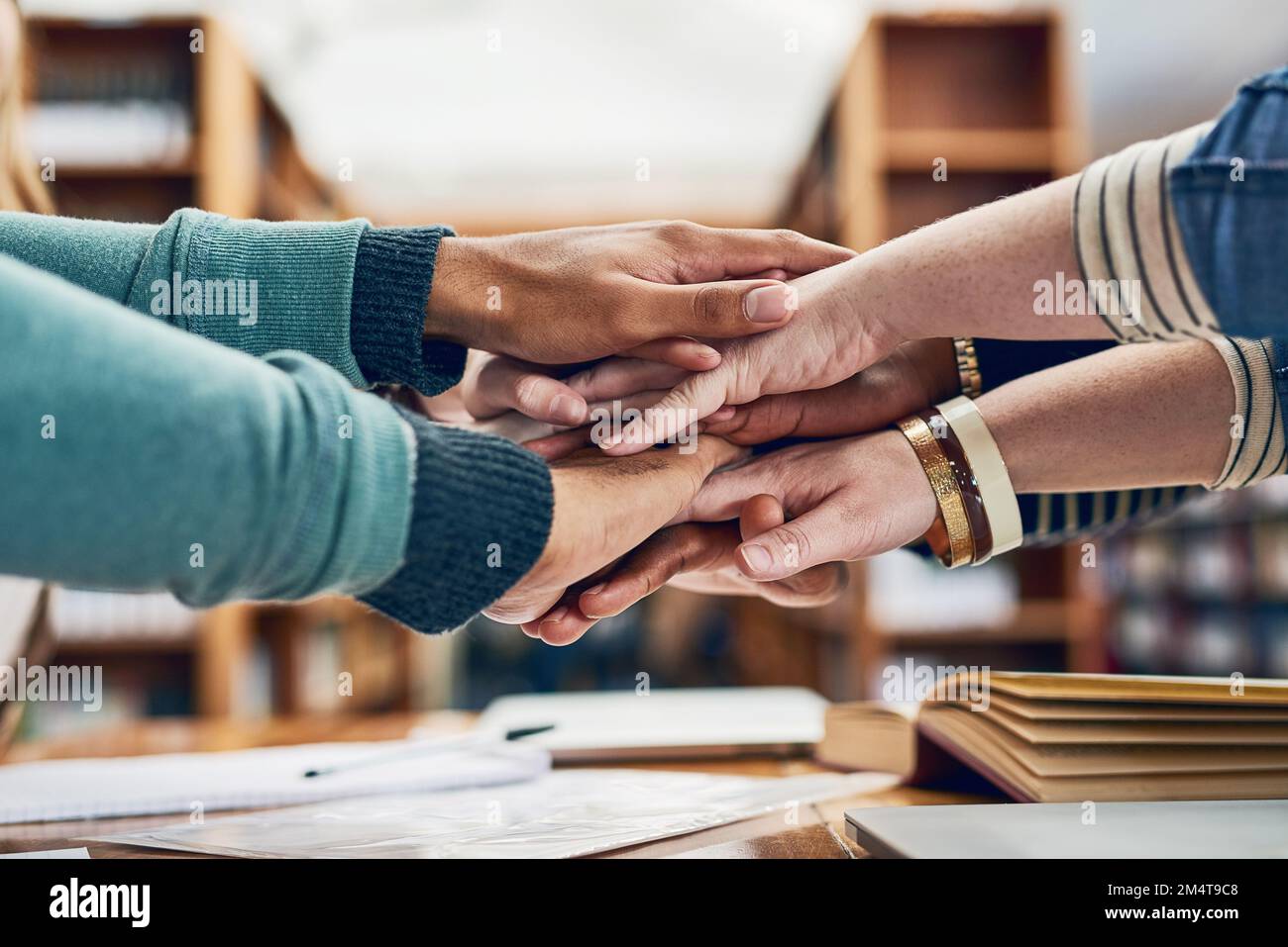 Heres to straight As. a group of students stacking their hands on top ...