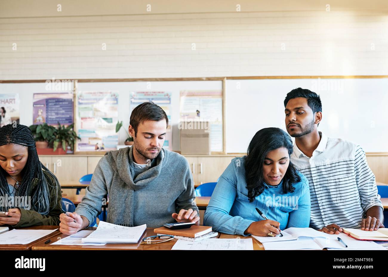 Trying to work it out. a group of young university students working in ...