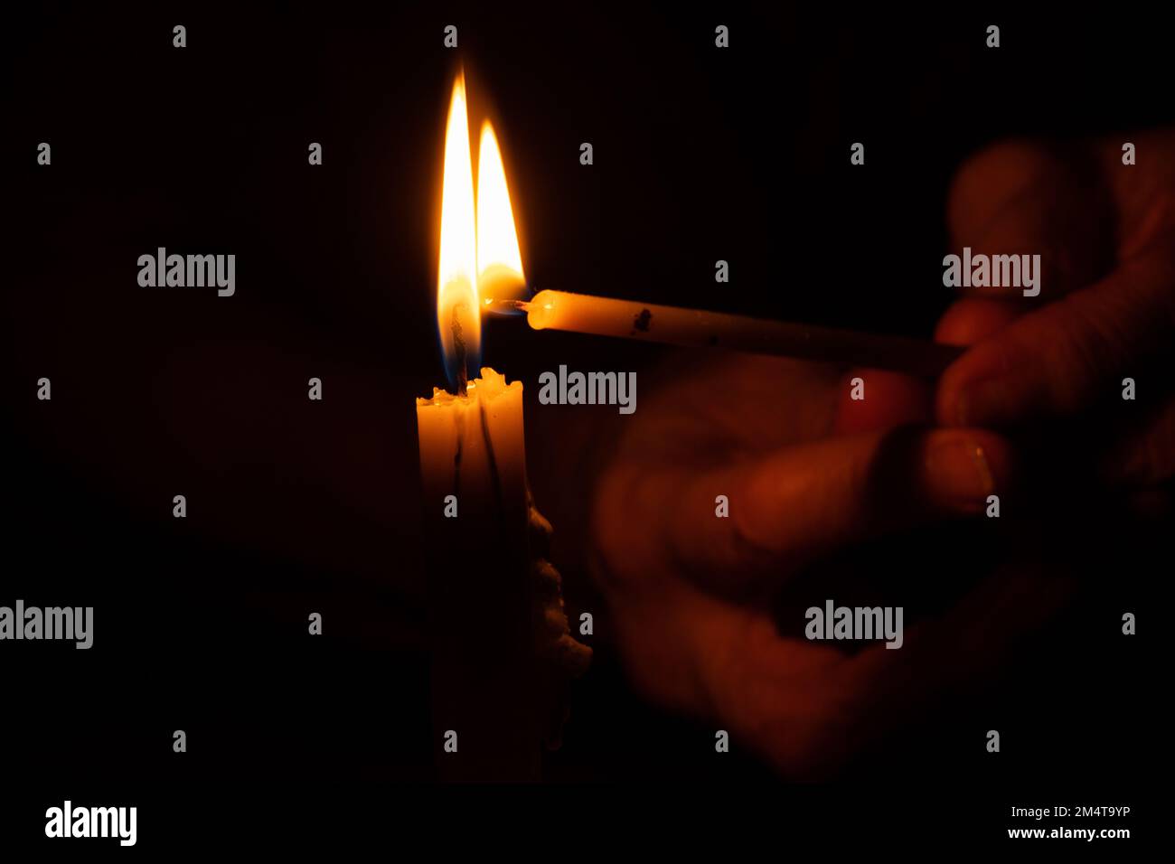 old woman's hands and candle flame in the dark, candle light, mourning ...