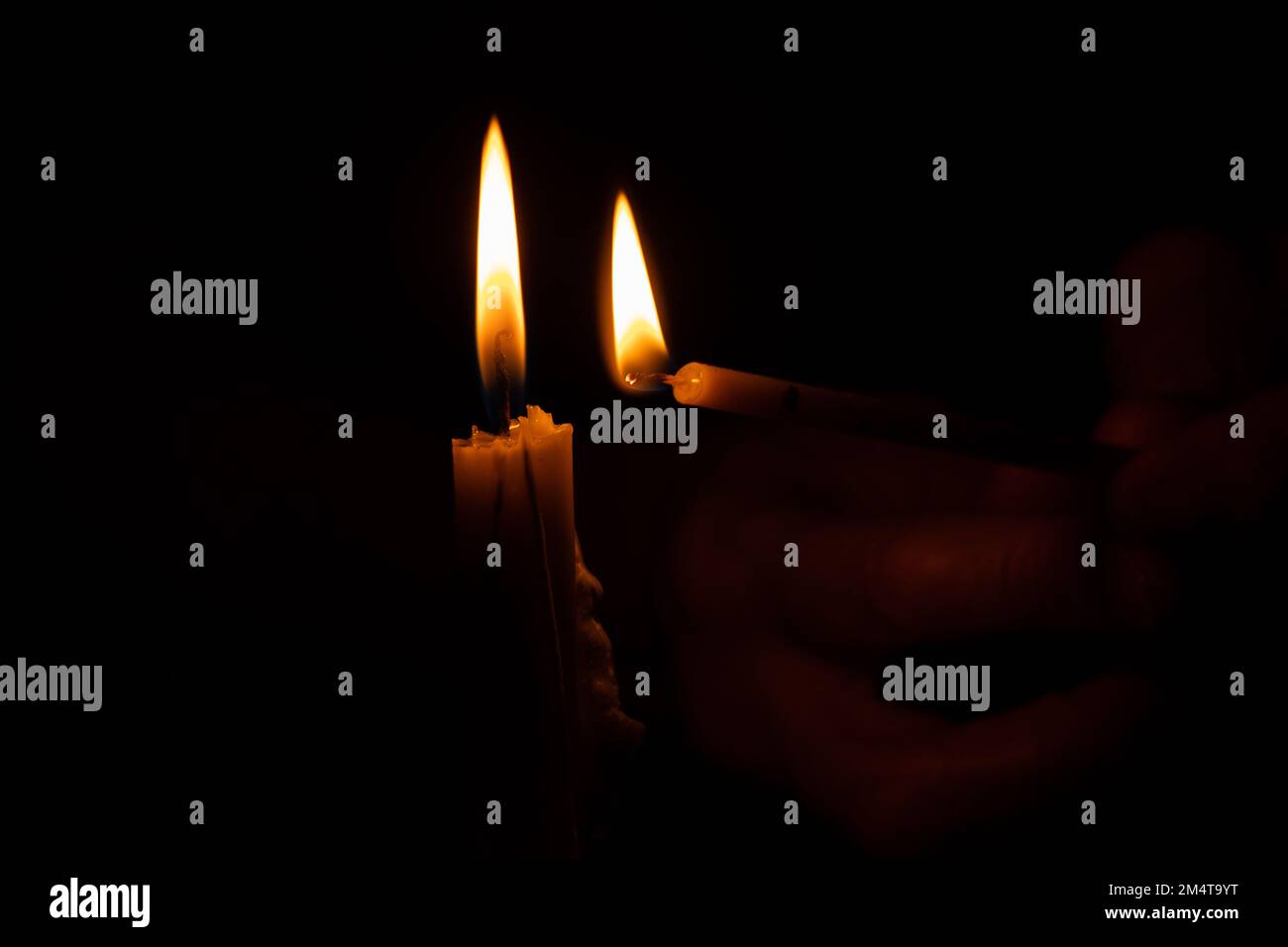 old woman's hands and candle flame in the dark, candle light, mourning ...