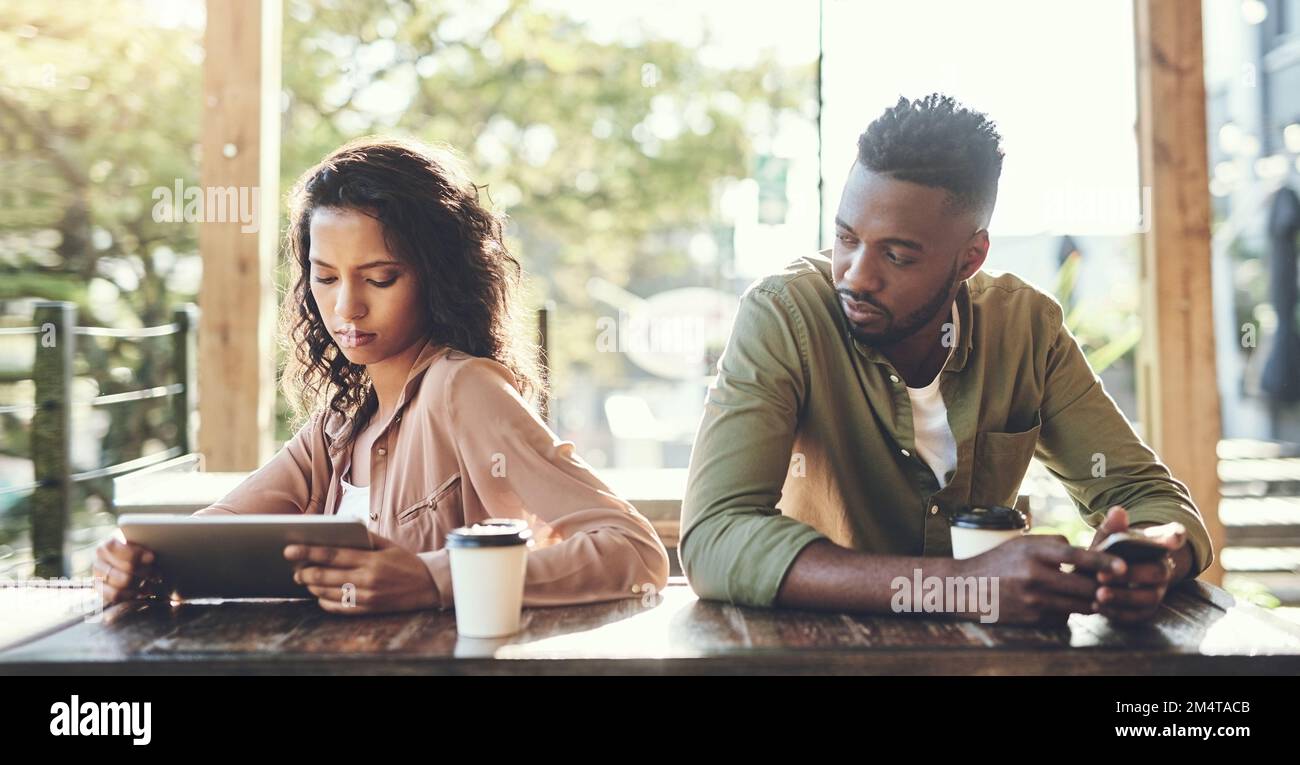 Technology is coming between them. two young people using their ...