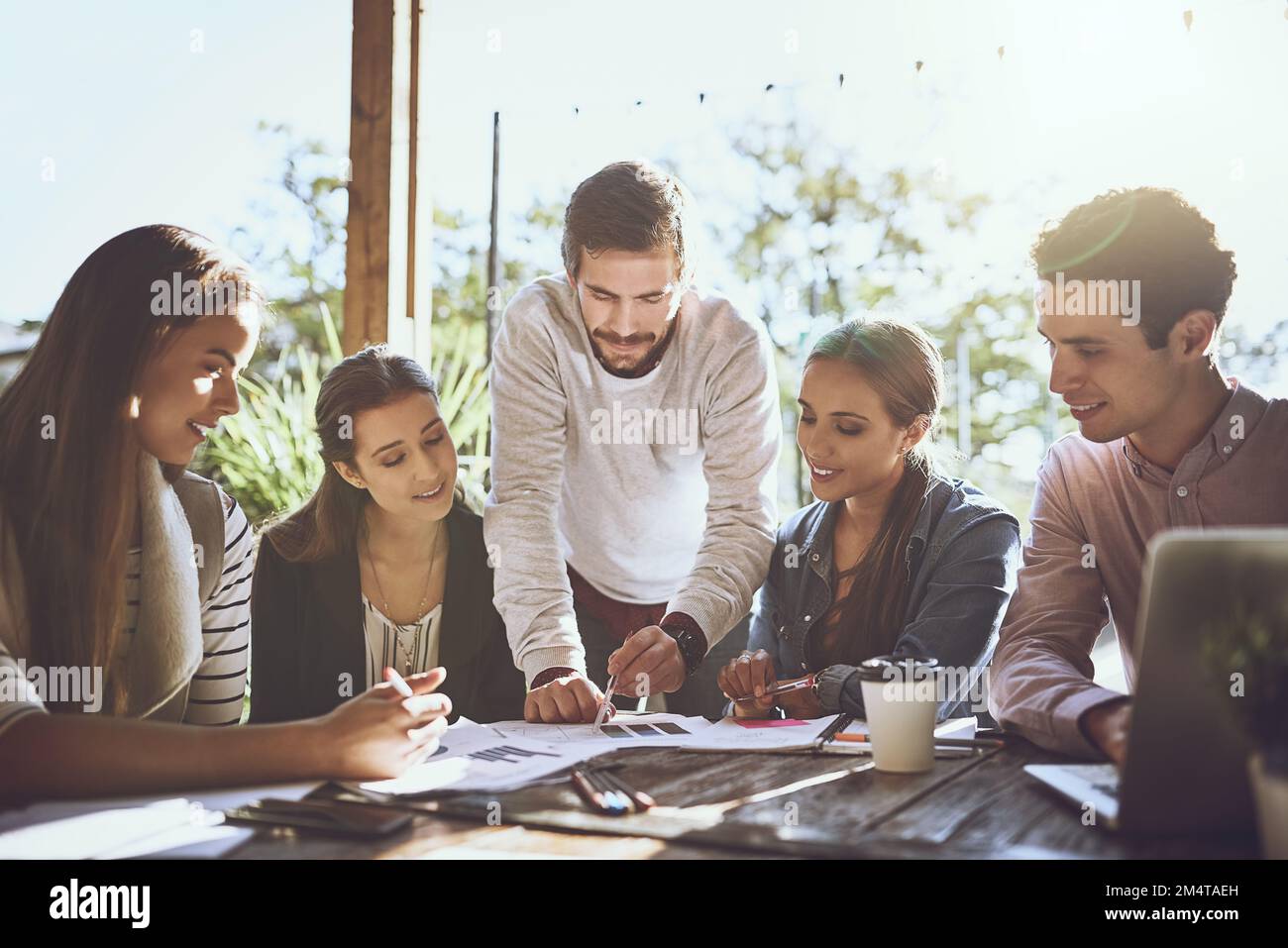 Moving their business meeting outside. a group of colleagues having a ...