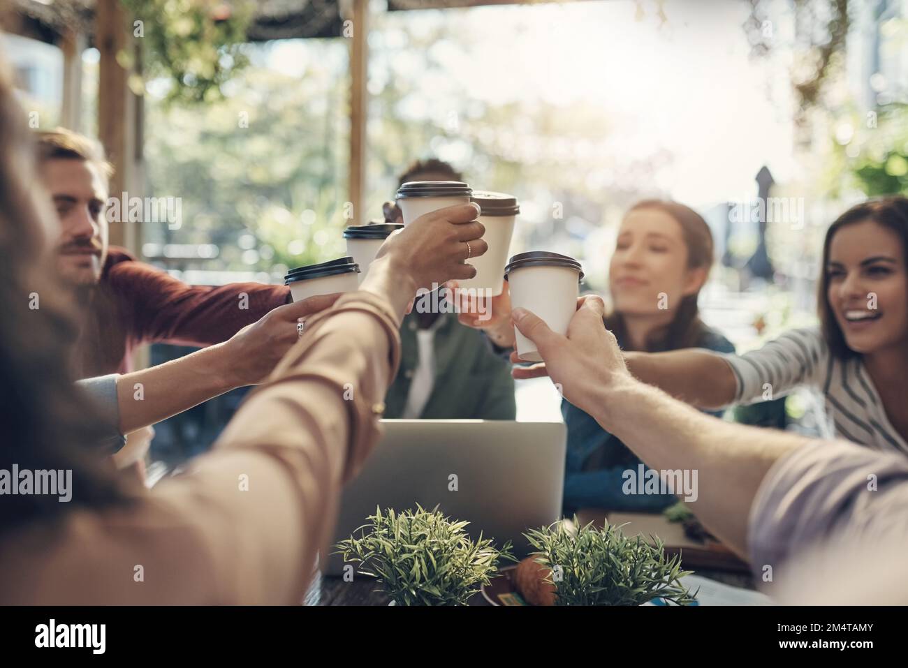 Toasting to their success. a group of creative employees toasting with ...