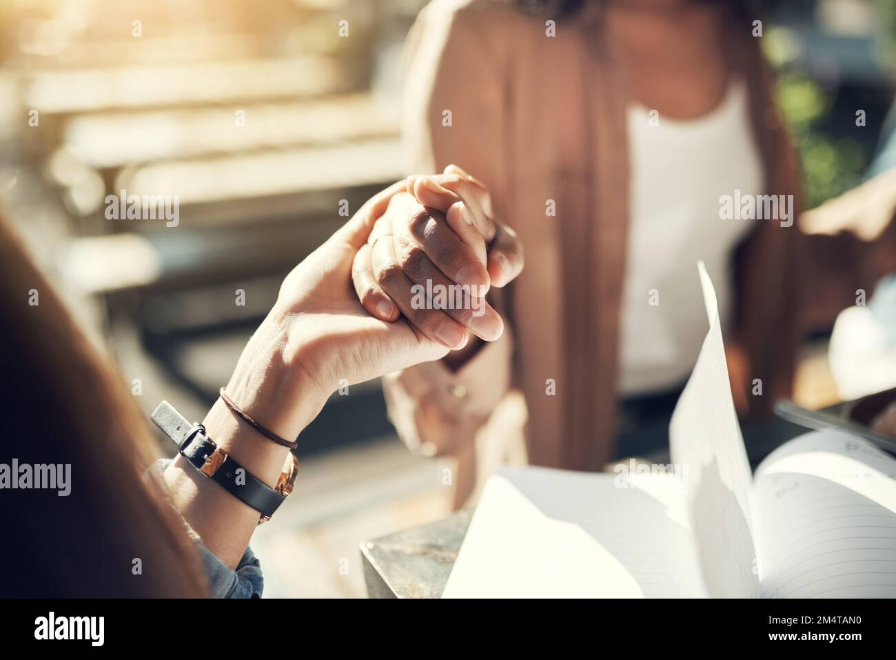 Saying grace. a group of creative employees holding hands and praying ...