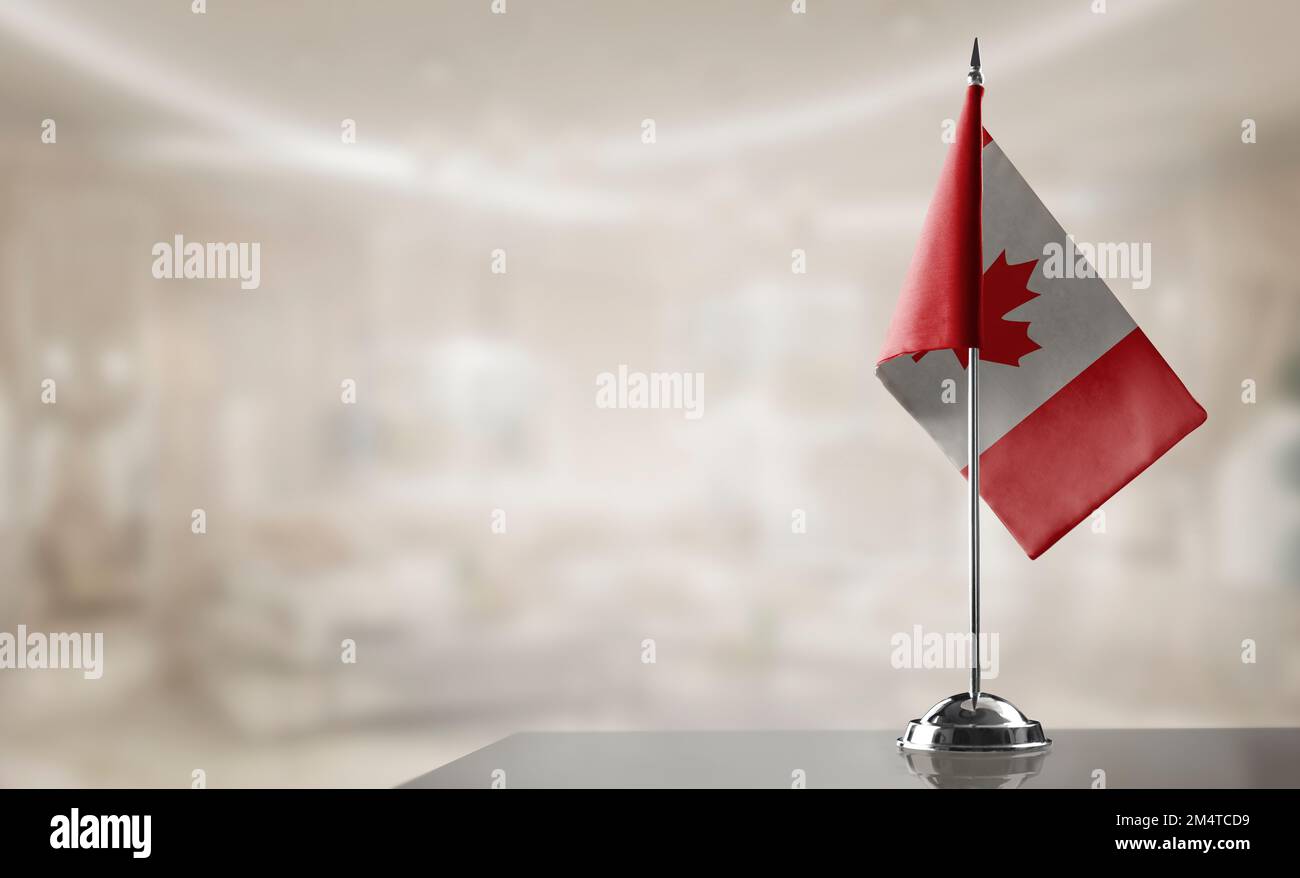 A small Canada flag on an abstract blurry background Stock Photo - Alamy