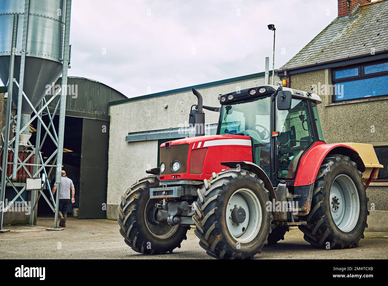Every farm needs a tractor. Full length shot of a tractor on a dairy ...