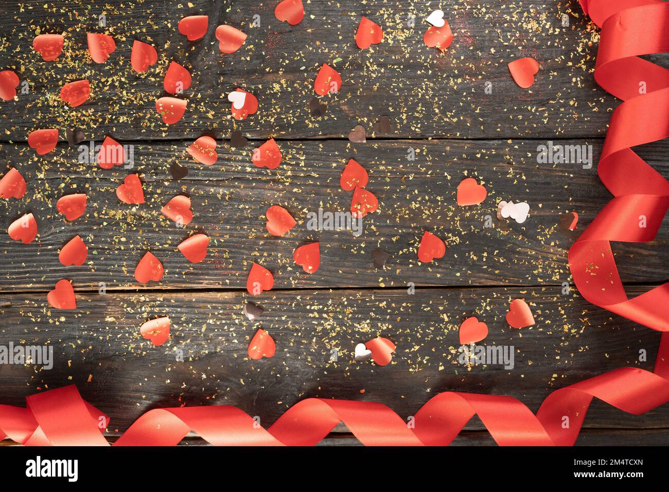 Wooden brown old background with red hearts and ribbon, top view. The ...