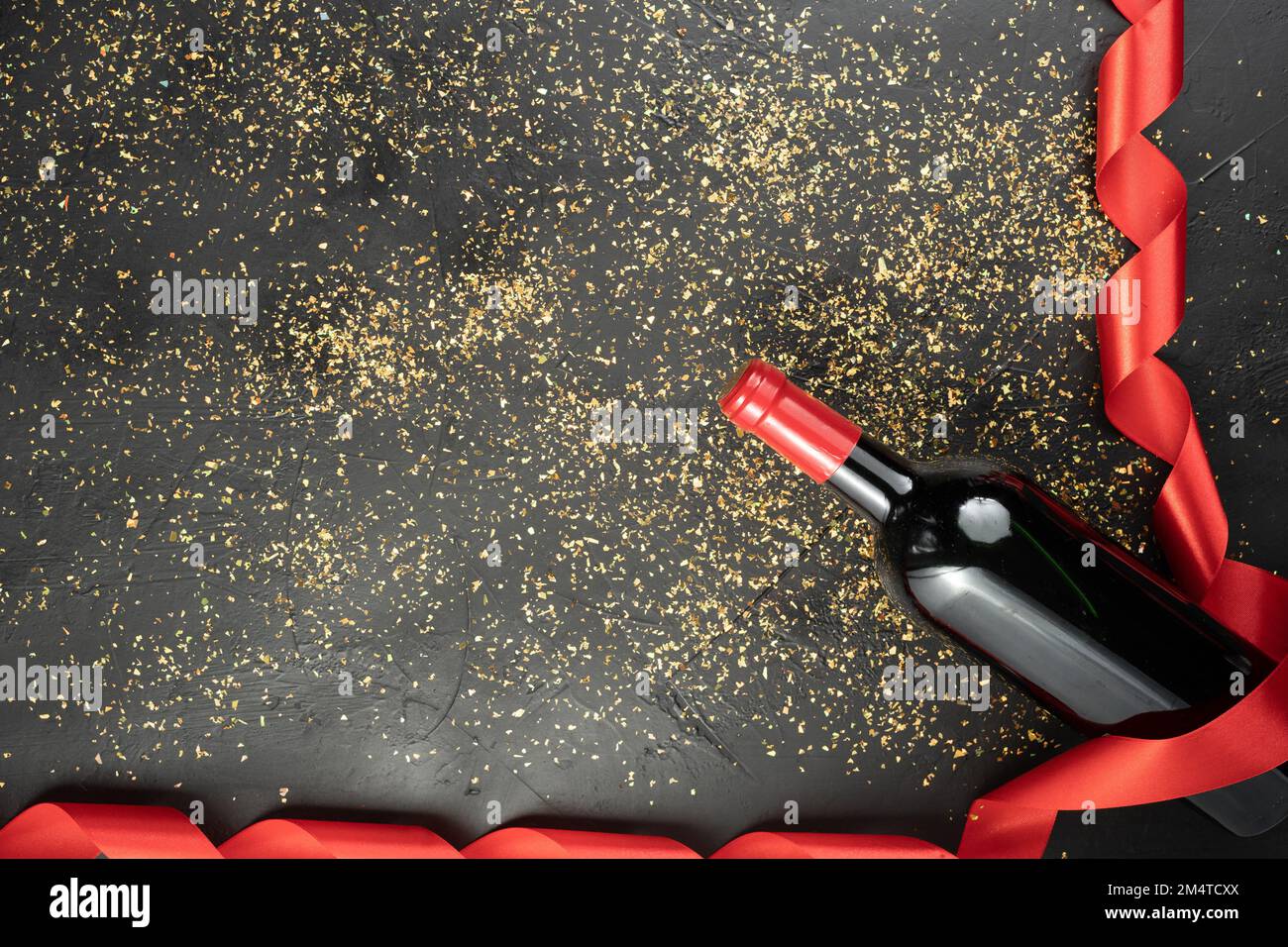 Wine bottle with a red satin ribbon bow. Valentine's Day. On a concrete ...