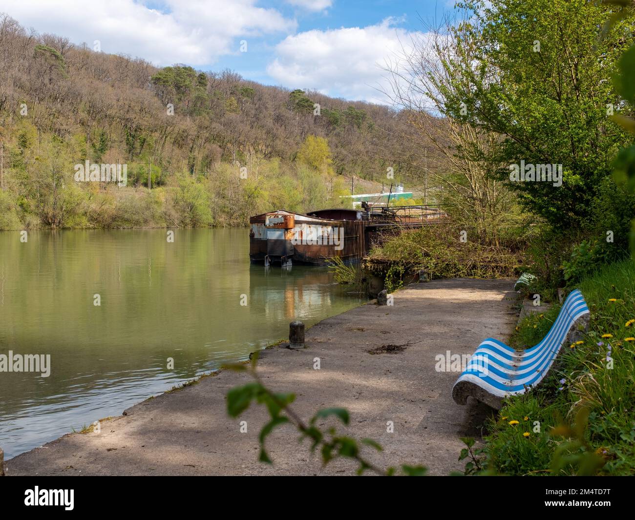 A barge and a bench in the countryside on the Seine River in the town ...