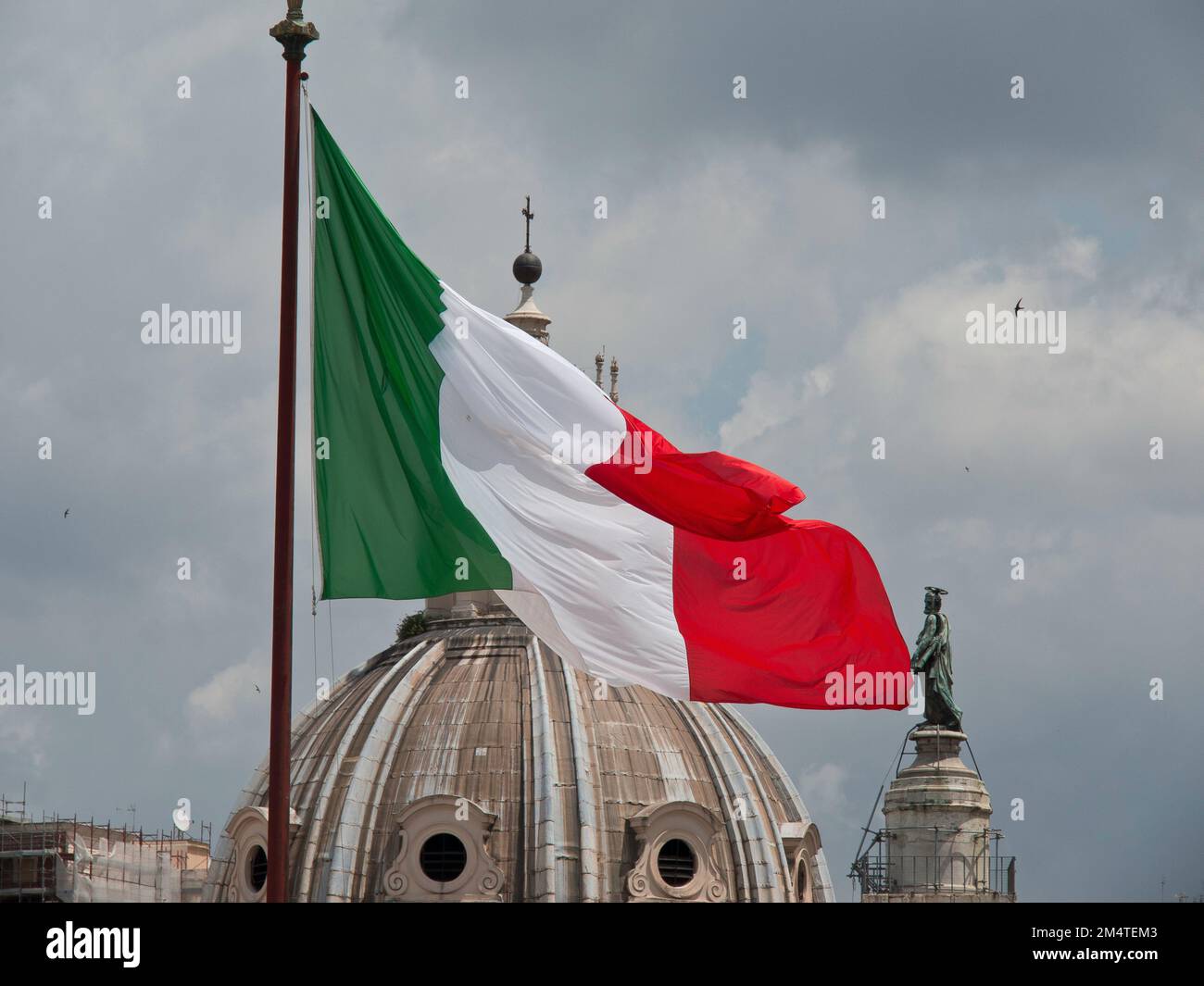 The Italian flag waving, with The Trajan Column and the church dome of ...