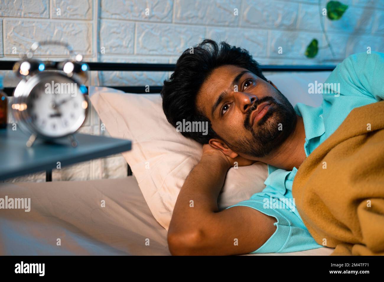 young man unable to sleep during night at bedroom - concept of ...