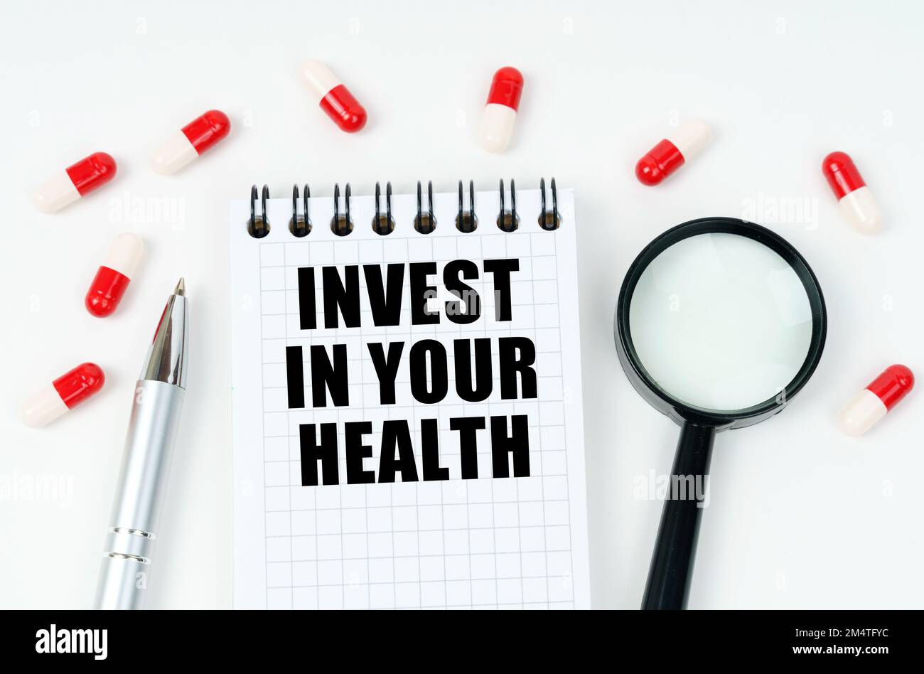 Medical concept. On a white surface are tablets, a pen, a magnifying ...