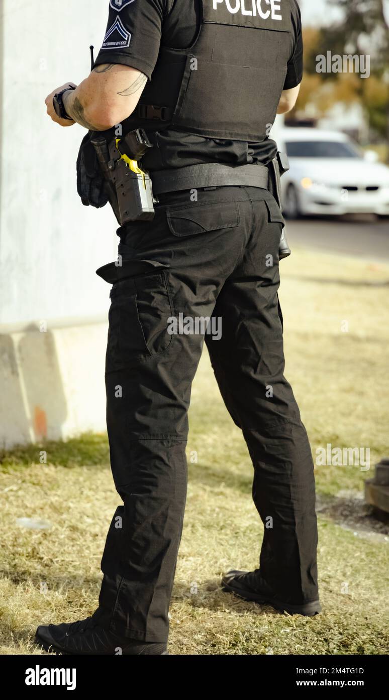 White male police officer cop standing on grass in a park during the ...