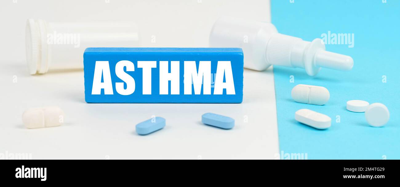 Medical concept. On a white and blue surface are pills, a spray and a ...