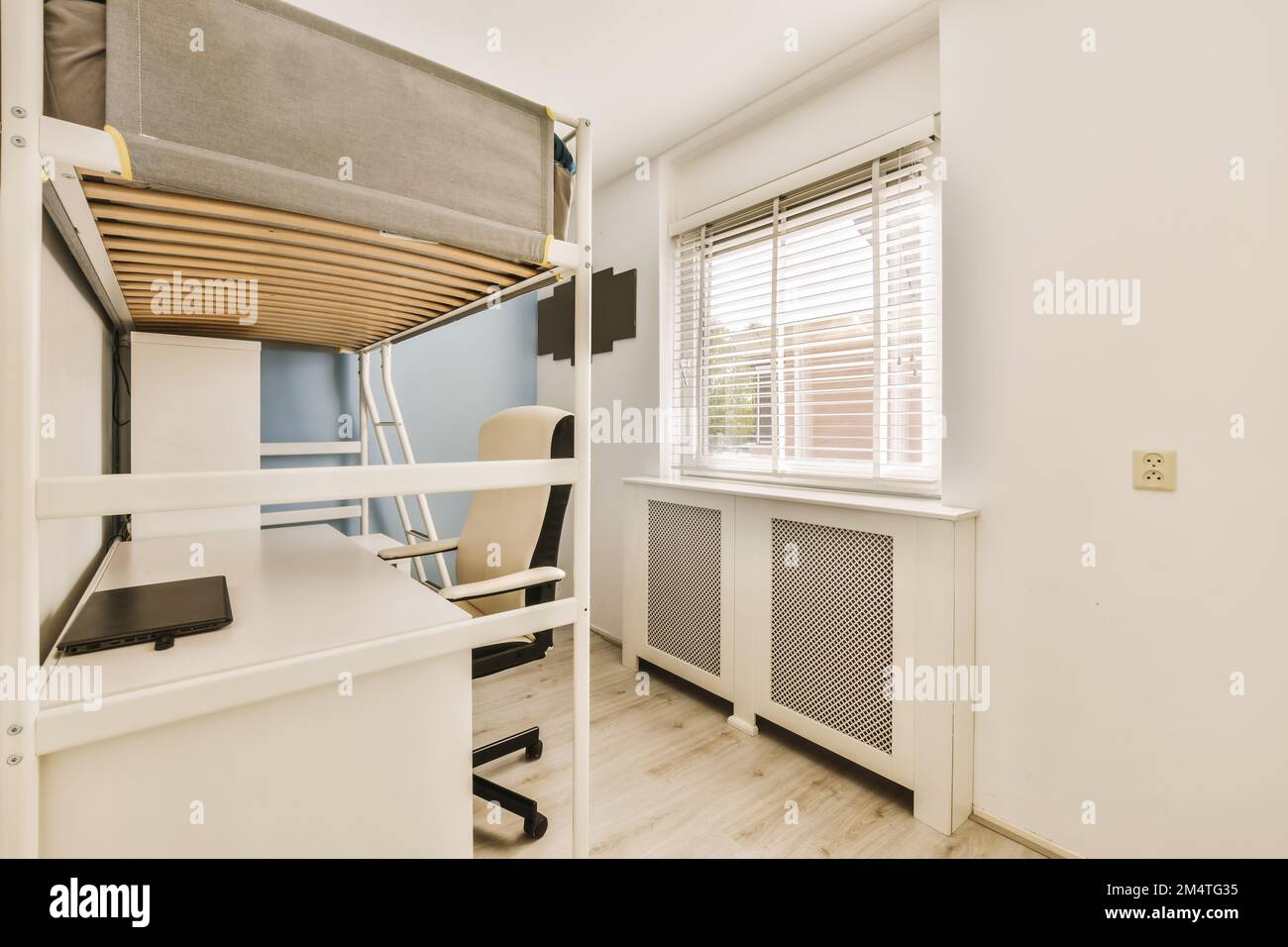 a small room with a bed, desk and computer on top of the bunk is in ...