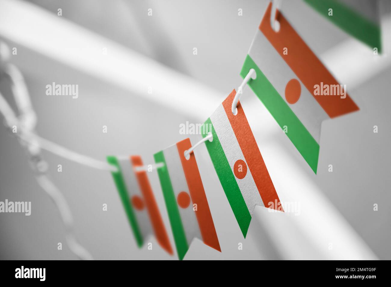 A garland of Niger national flags on an abstract blurred background ...
