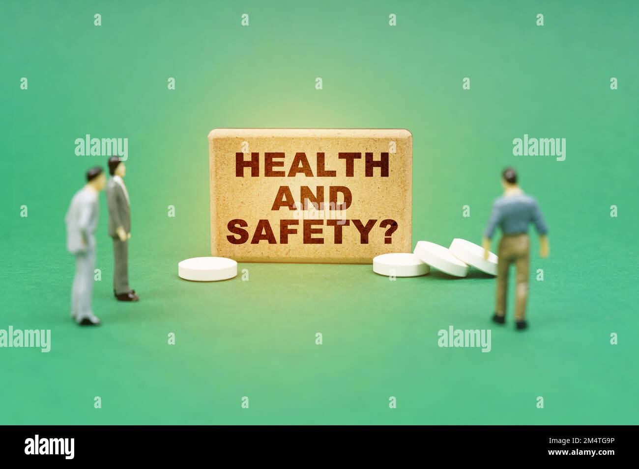 Medical concept. On the green surface are pills, miniature figures of ...