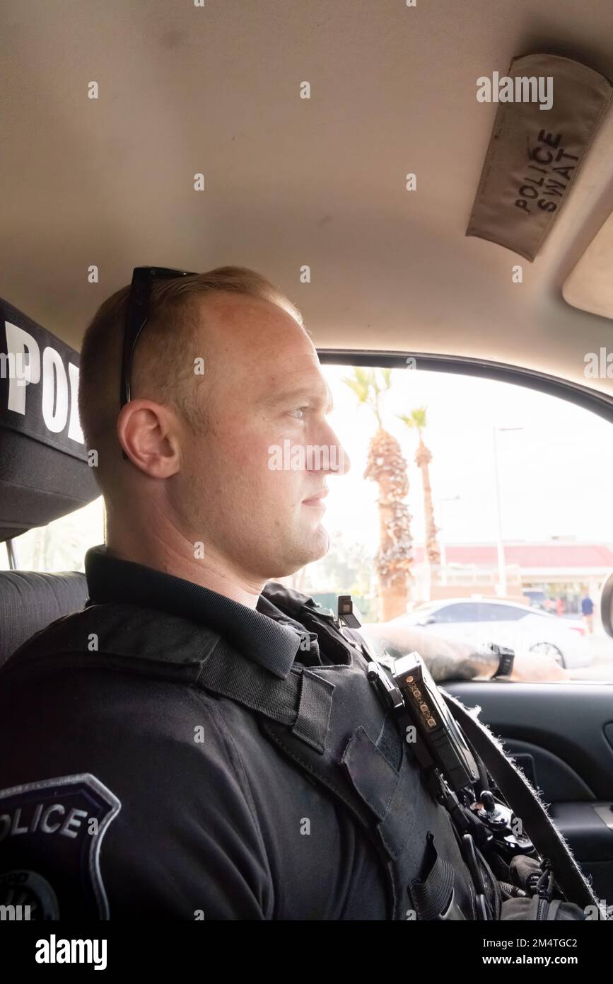 Vertical image of white male caucasian police officer driving in his ...
