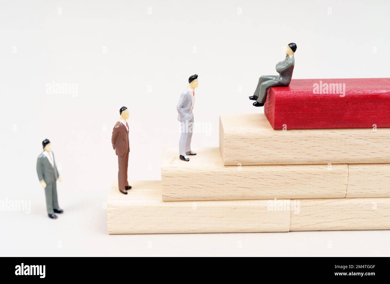 Corruption concept. Figures of people rise on wooden blocks. At the top ...
