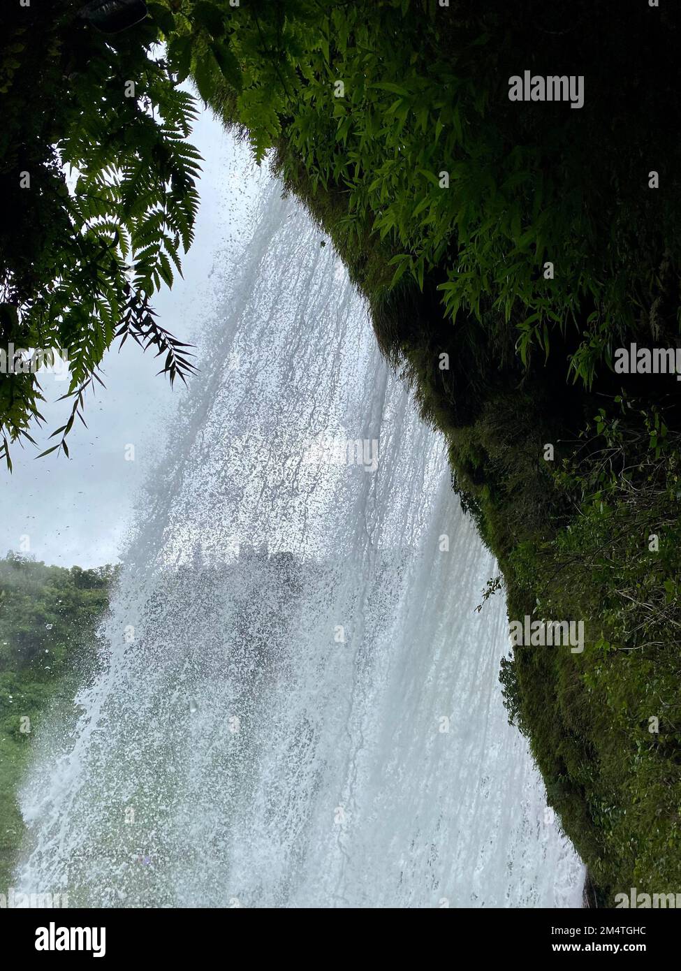 The vertical low-angle view from a cave to the waterfall Stock Photo ...