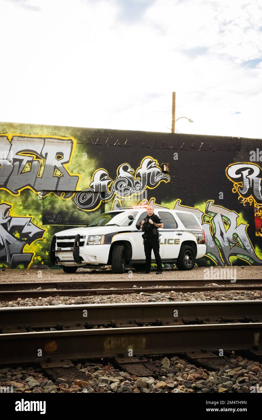 Vertical image of white male caucasian police officer posing in front ...