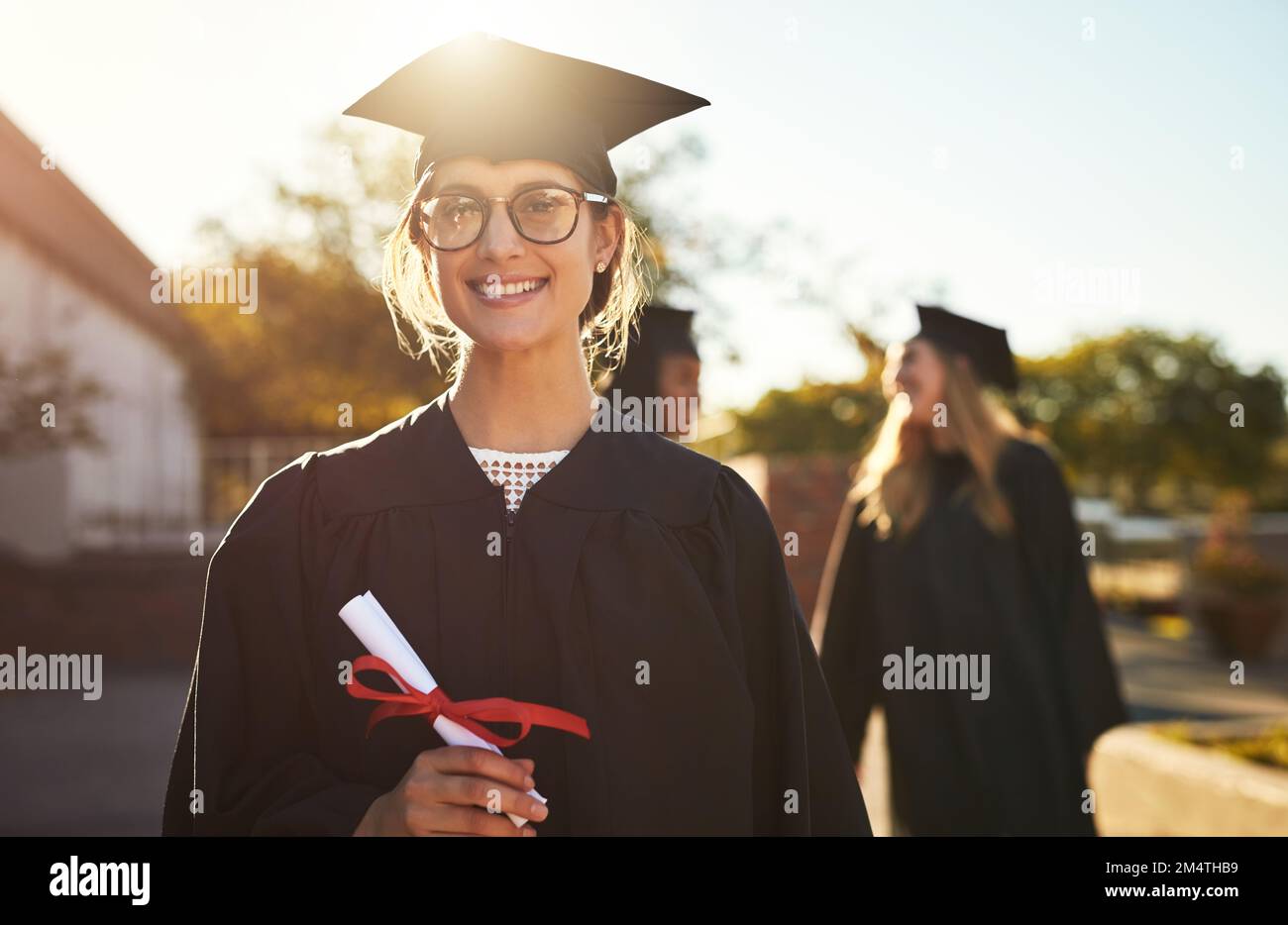 Glad to be a grad. Portrait of a happy young woman holding a diploma on ...