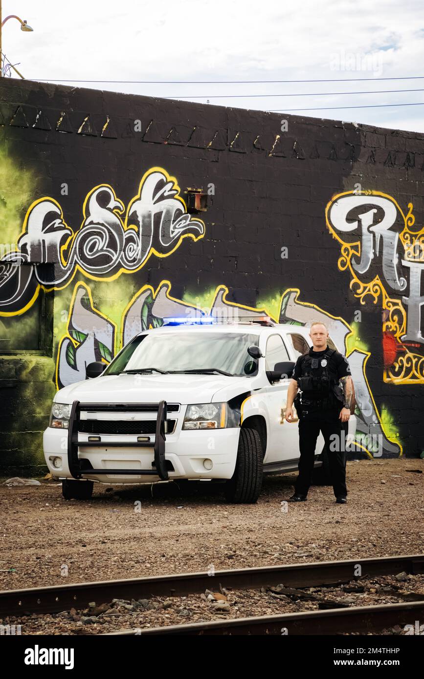Vertical image of white male caucasian police officer posing in front ...