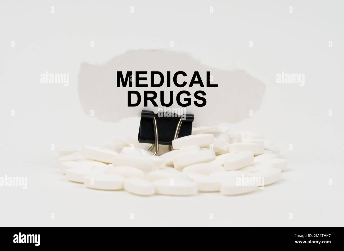 Medical concept. On a white surface are pills and torn paper with the ...