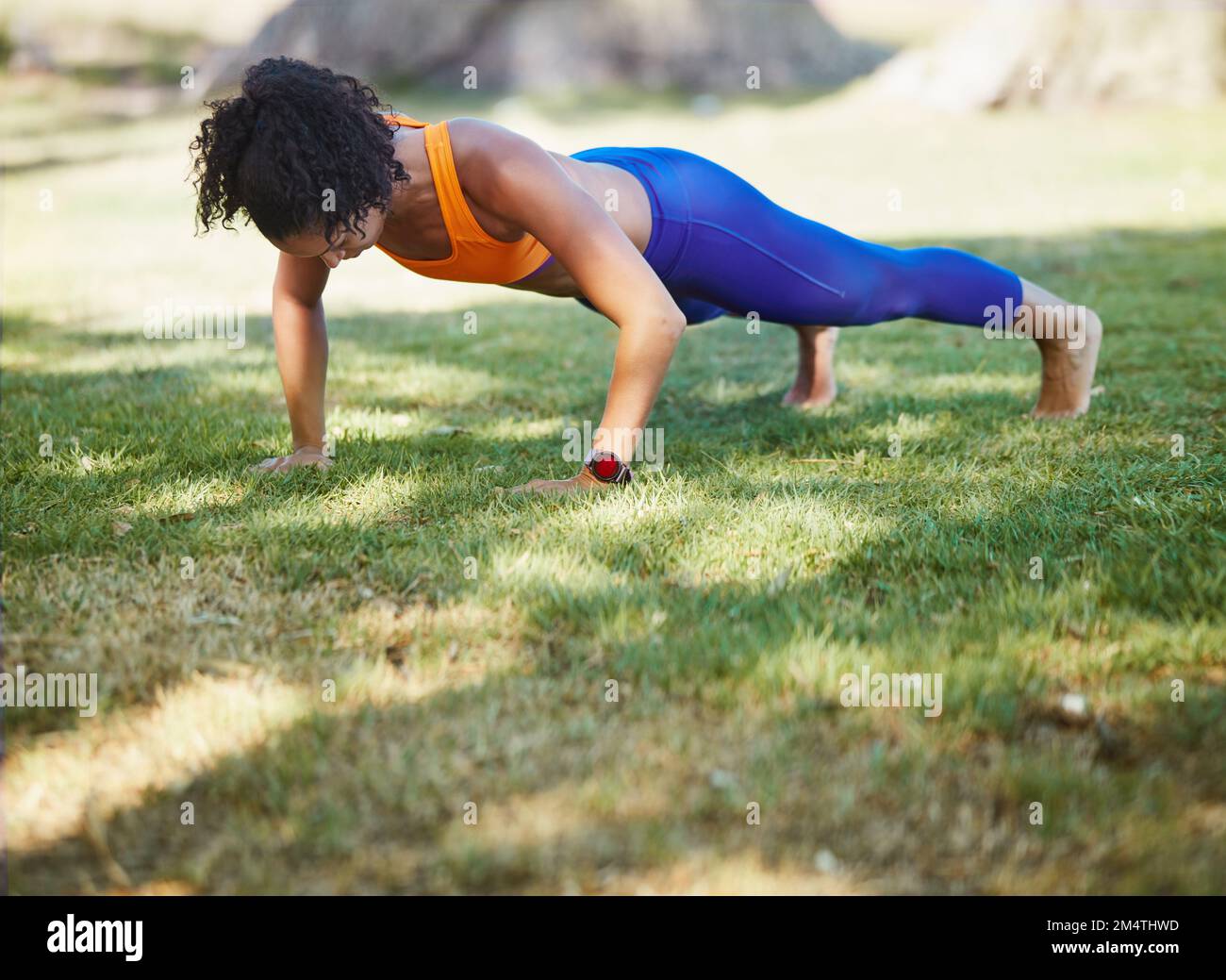 Push yourself to do better. a sporty young woman doing push ups as part ...