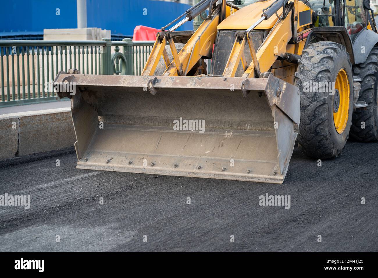Repairing motor road with excavator with empty bucket driving on ground ...