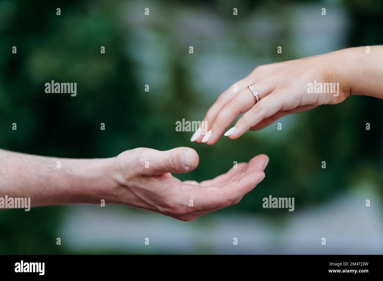 A female hand with a wedding ring touching the male fingers Stock Photo ...