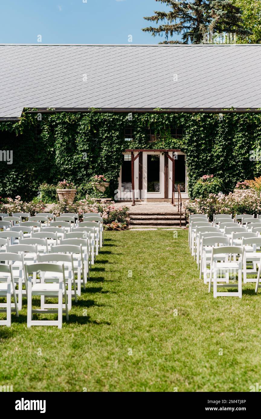 A vertical shot of the rows of chairs on the lawn outside for a wedding ...