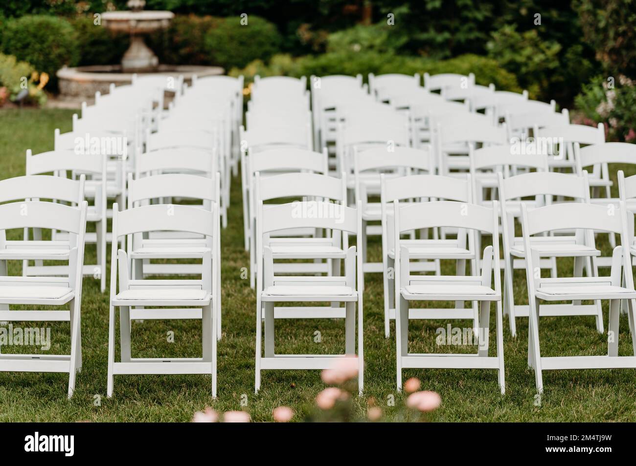 The closeup shot of the rows of chairs on the lawn outside for a ...