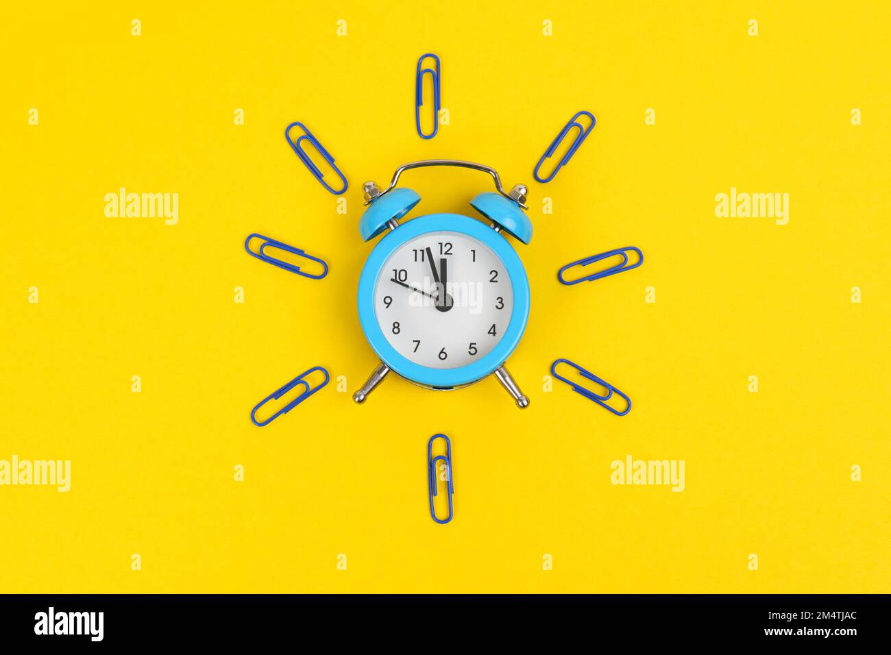 Education concept. On the yellow surface lies a blue alarm clock and ...
