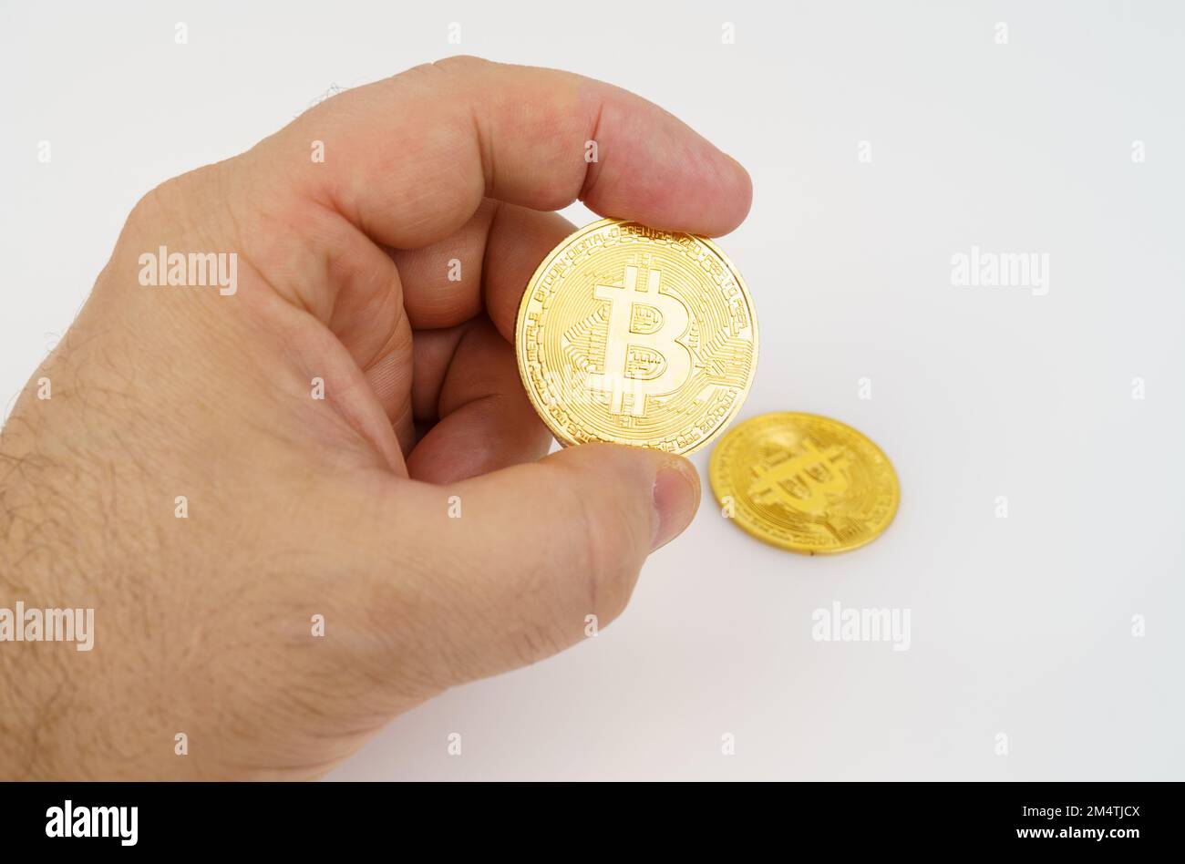 Cryptocurrency and business concept. A man holds a bitcoin in his hand ...