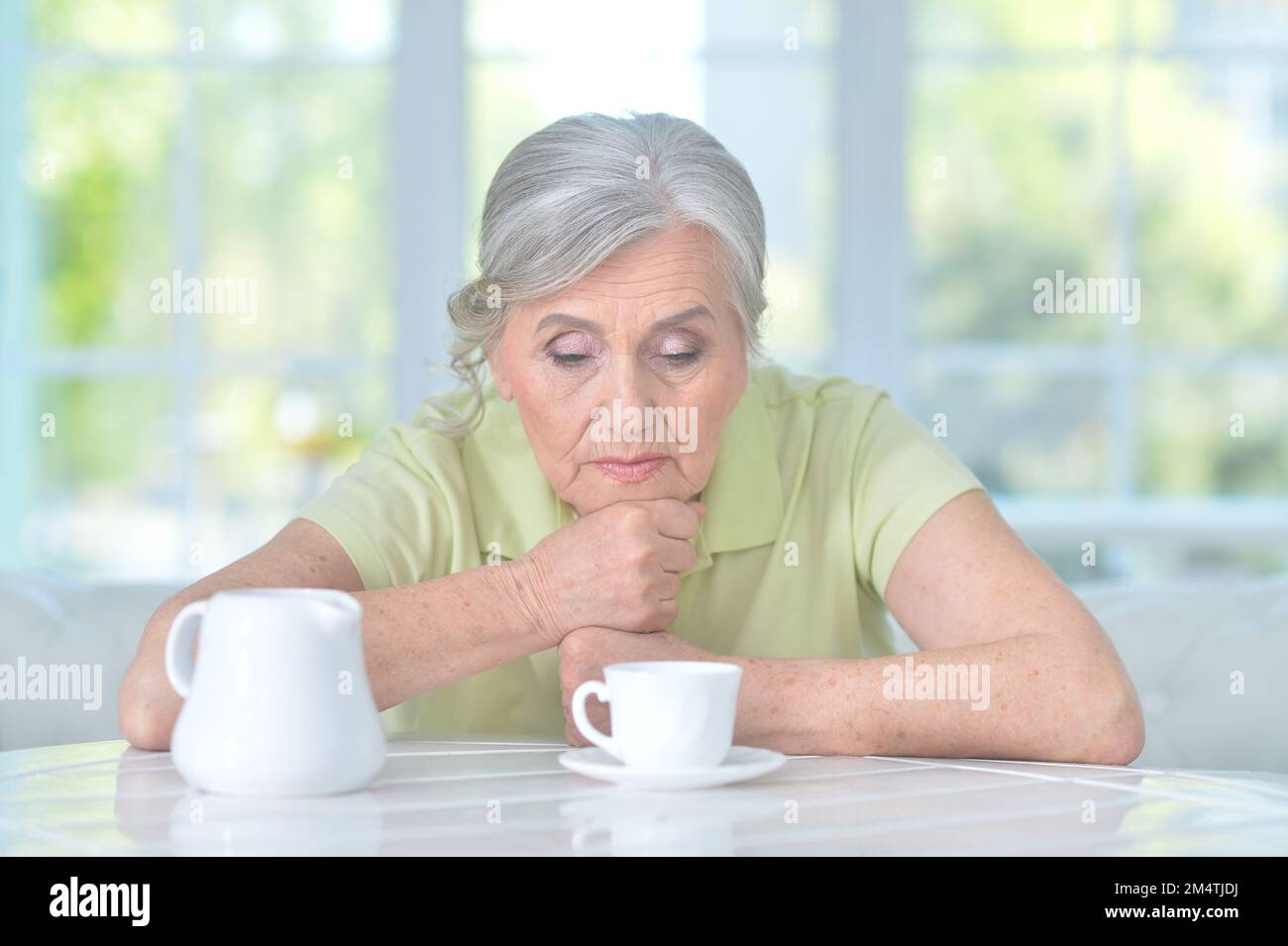 sad old woman drinking tea at home Stock Photo - Alamy