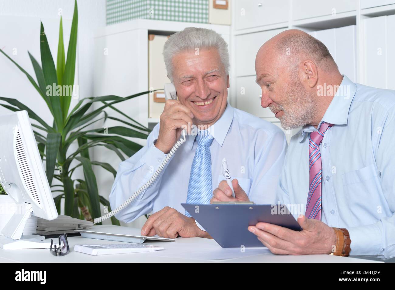 two old elderly businessmen working in office Stock Photo - Alamy
