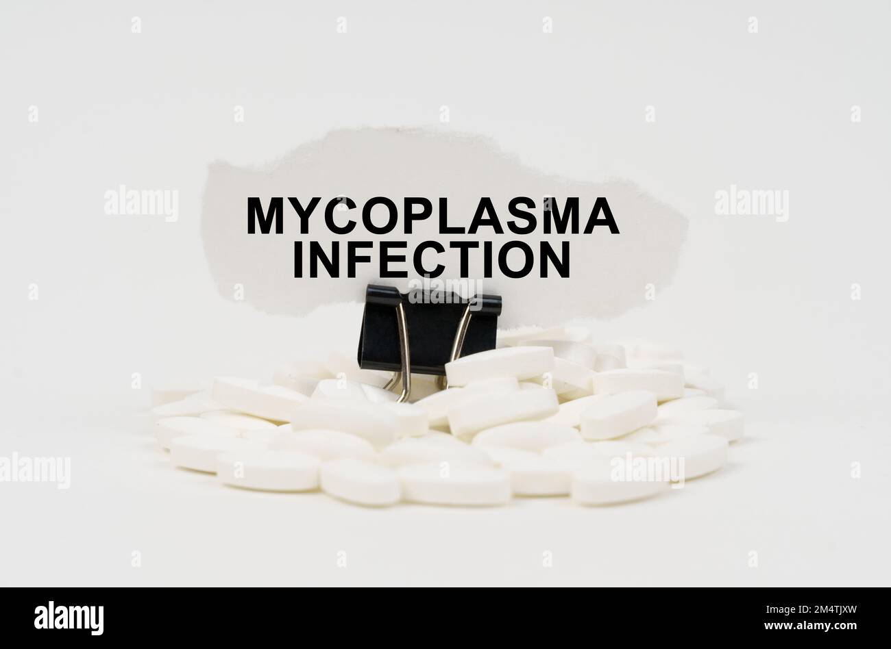 Medical concept. On a white surface are pills and torn paper with the ...