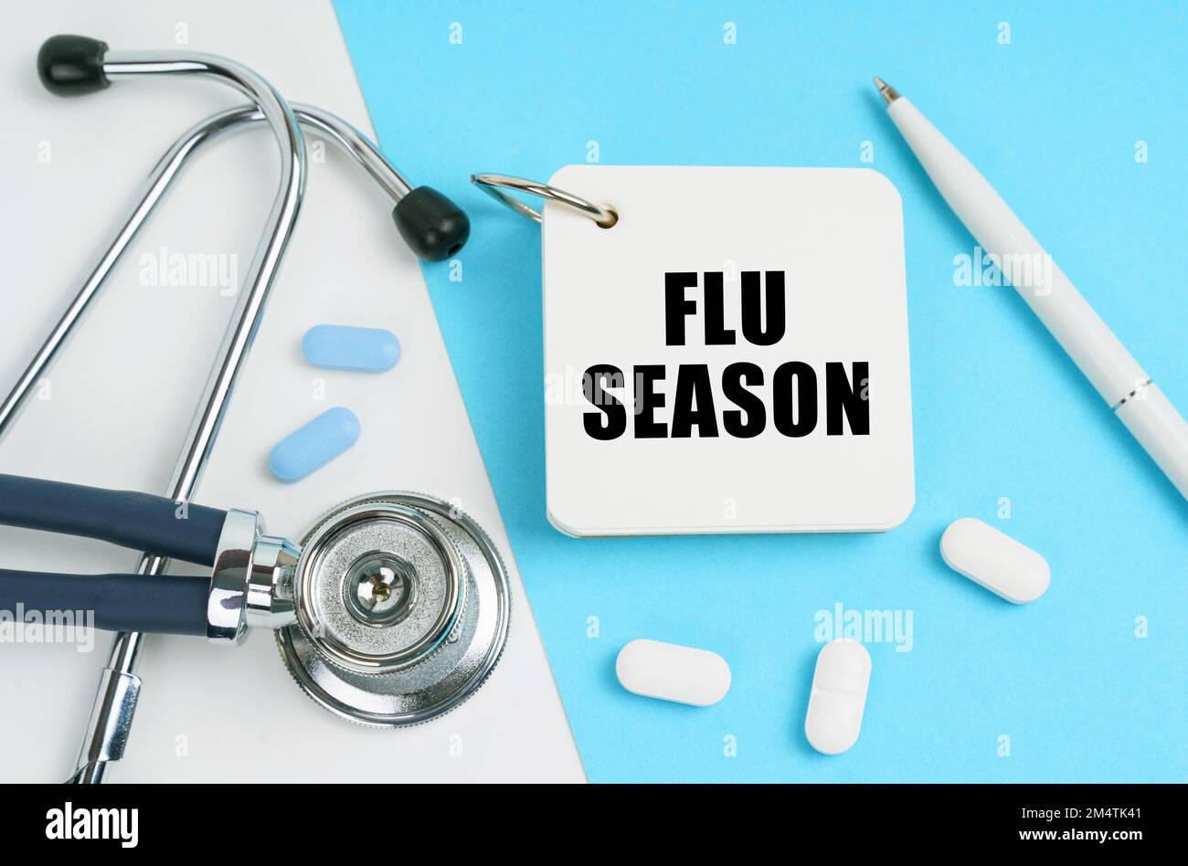 Medical concept. On a white and blue surface are pills, a stethoscope ...