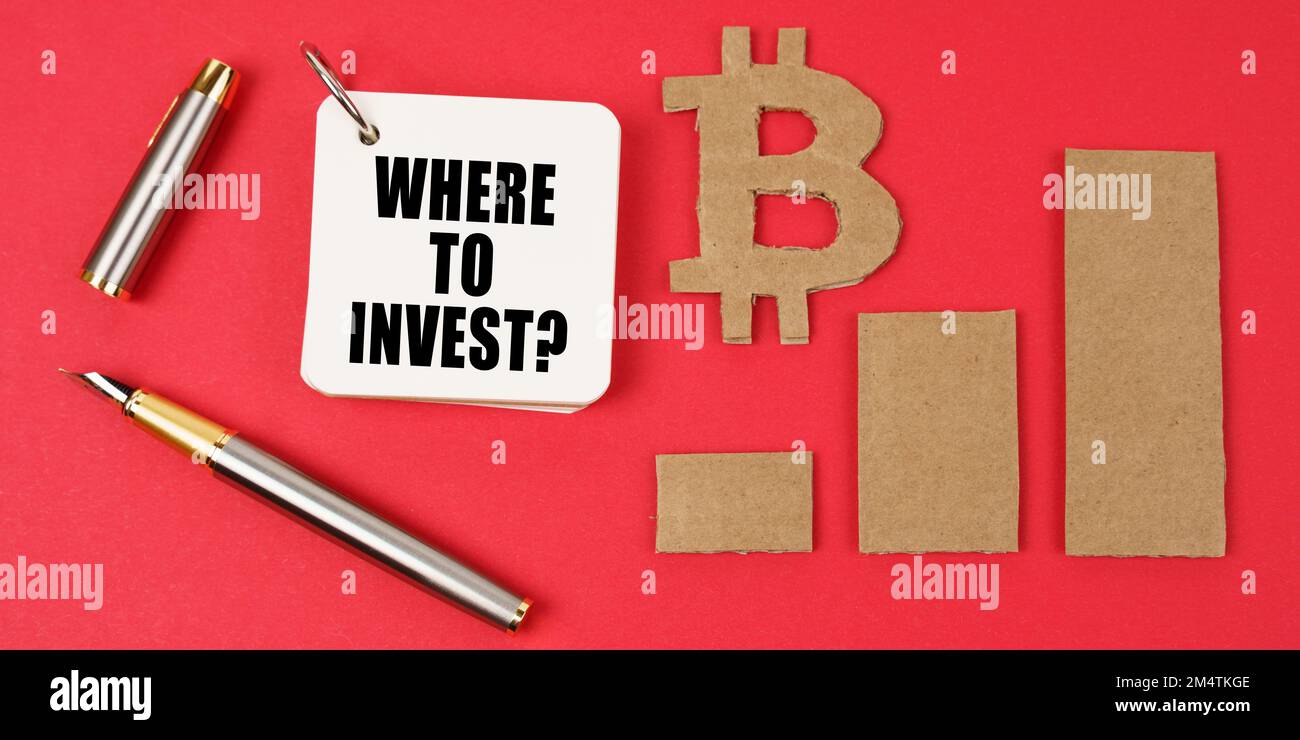 Business and bitcoin concept. On a red surface lie a bitcoin symbol, a ...
