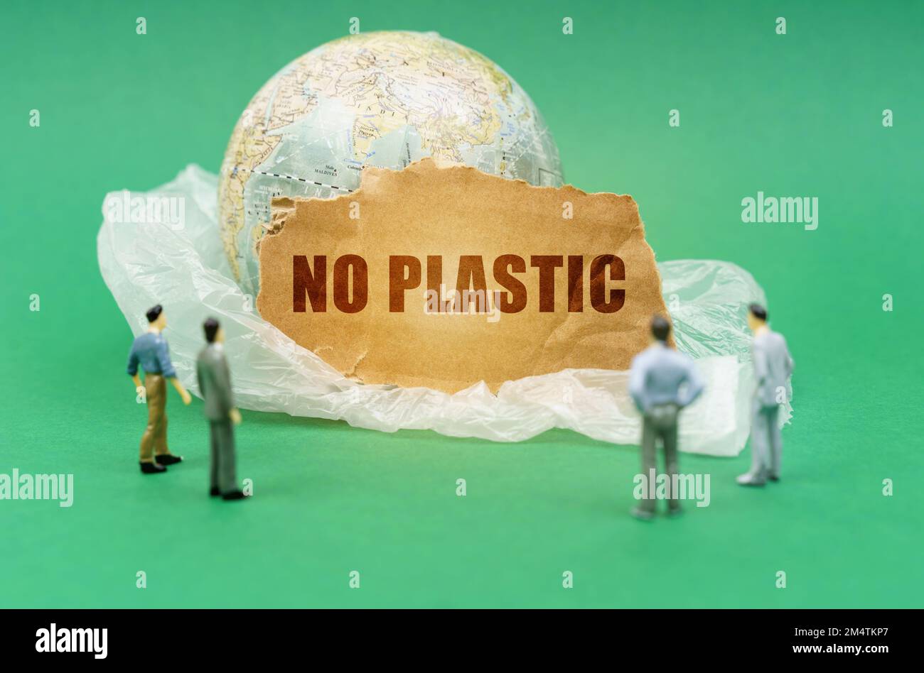 Ecological concept. On a green background on a plastic bag is a globe ...
