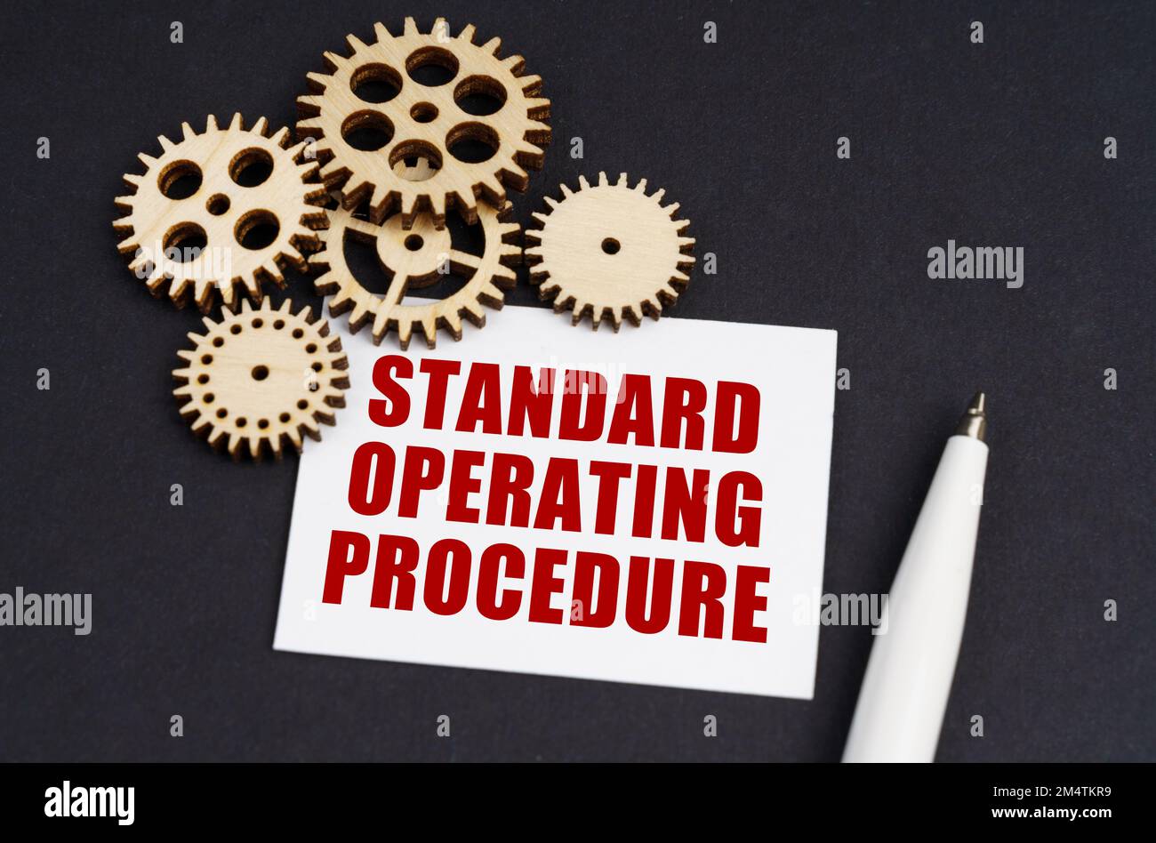 Industrial concept. On the black surface are gears, a pen and a ...