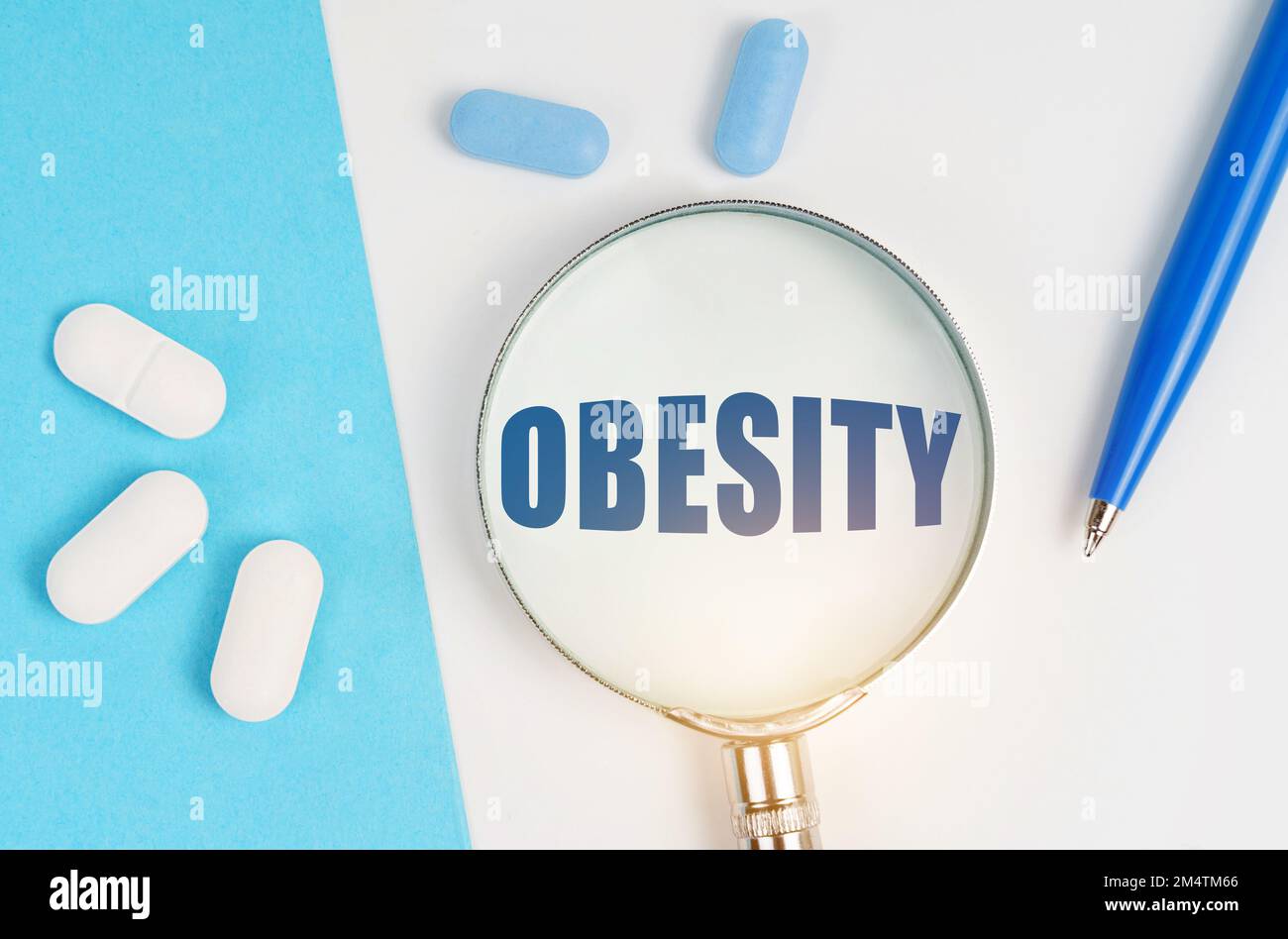 Medical concept. On a white and blue surface are pills, a pen and a ...