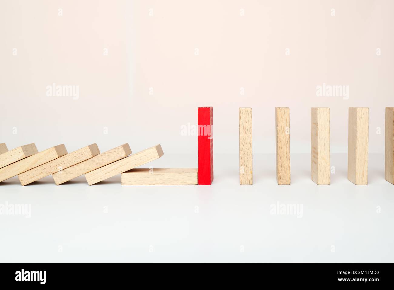 One red domino is standing, and the other wooden dominoes have fallen ...